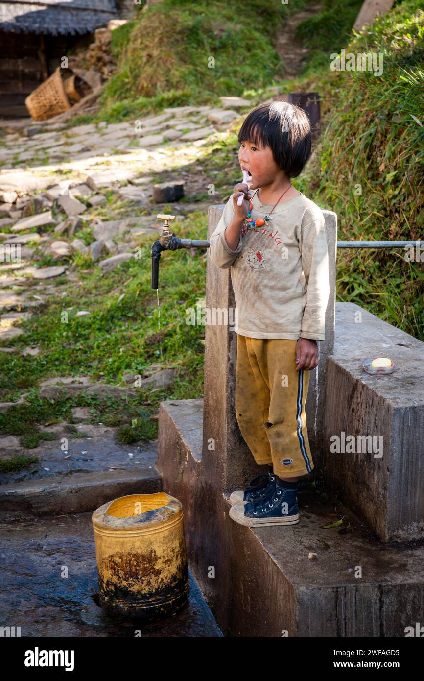 Young Bhutanese Girl Brushes Her Teeth With Water Coming Out Of An Outdoor Faucet Piped Into The