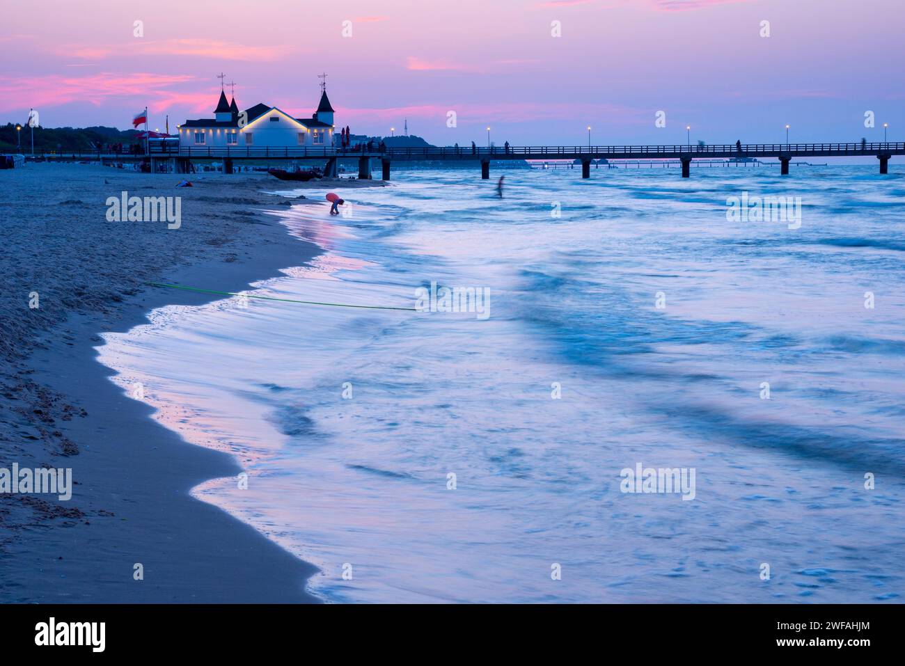 Calm evening mood on the beach with calm waves and two people near a ...