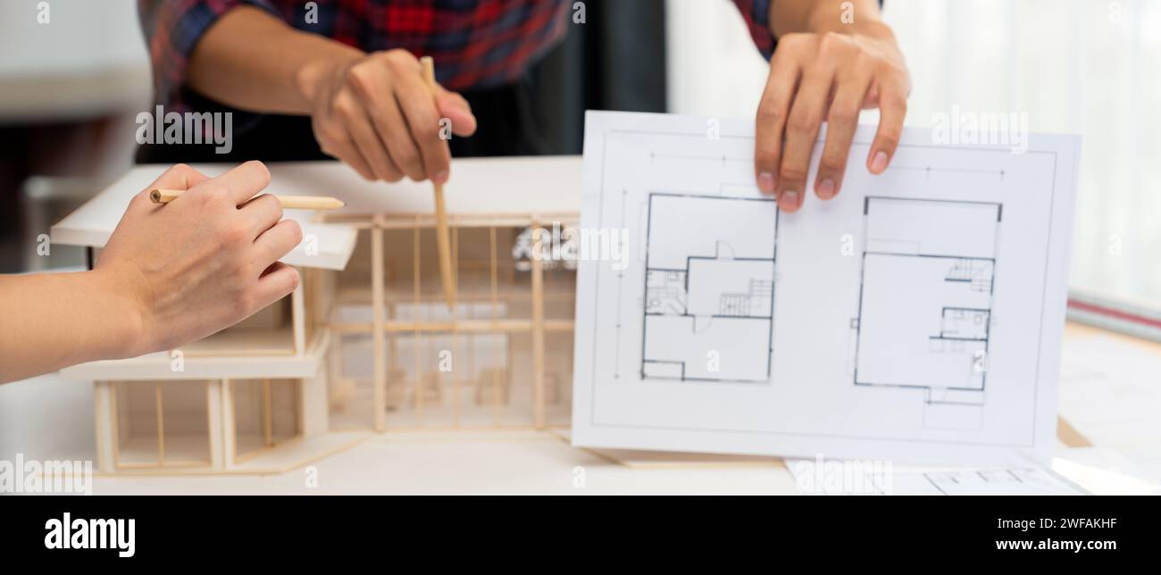Cropped image professional architect hand compare construction between ... Cropped image professional architect hand compare construction between ...