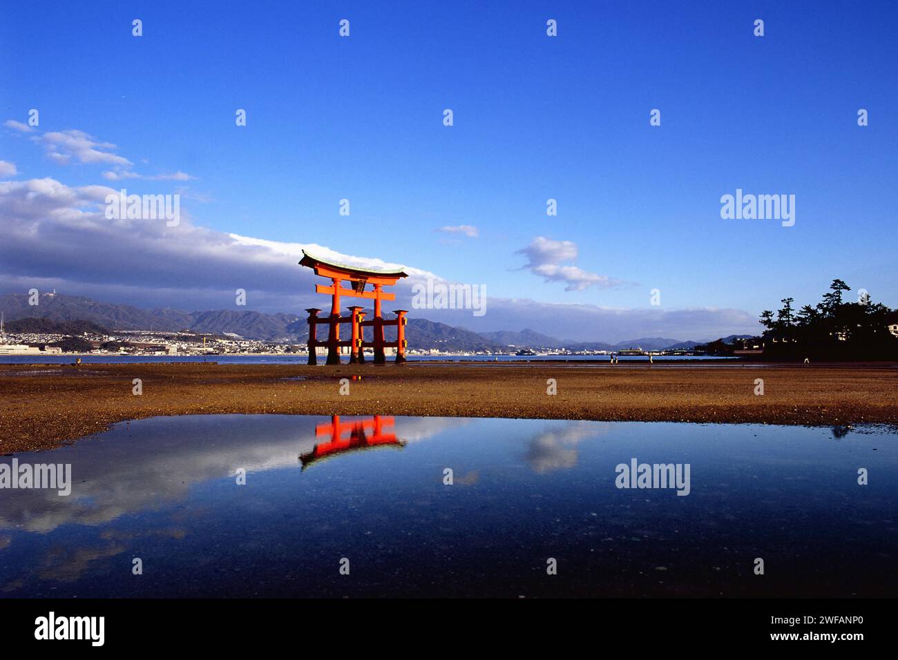 The bright red Sea-gate of Miyajima temple, Japan, against a background ...