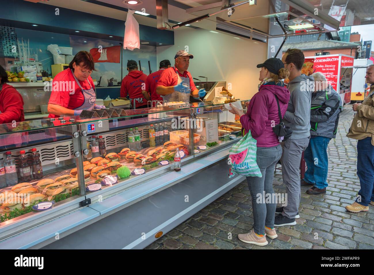 Hamburg, Germany - July 17, 2022: tourists buying fish burger at shop ...