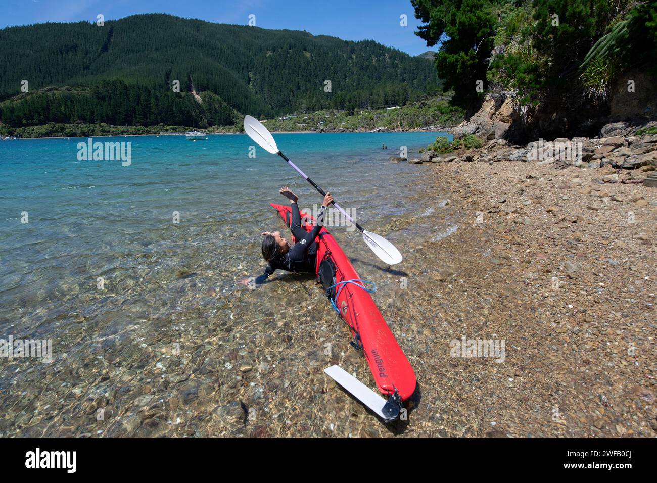 Woman falling out from kayak while exiting, Elaine Bay, Pelorus Sound ...