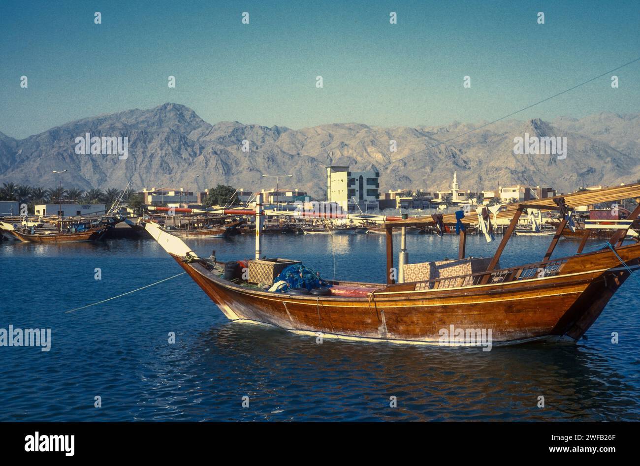 Dhows at anchor off Dibba, Fujairah Emirate, UAE. Mountains of Oman's ...