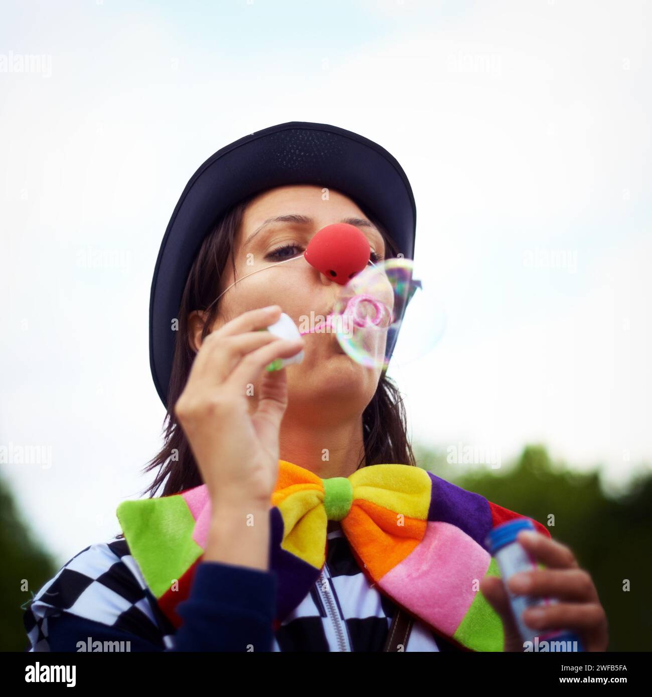 Clown blowing bubbles at outdoor festival for fun, fantasy and summer ...