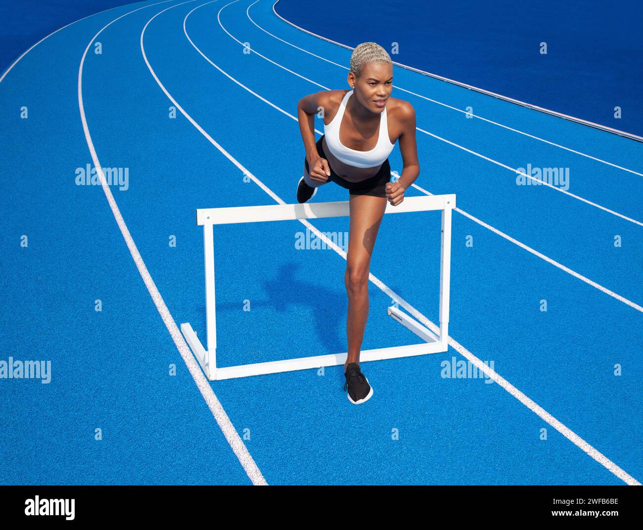 An African American female athlete is running on the Olympic track ...