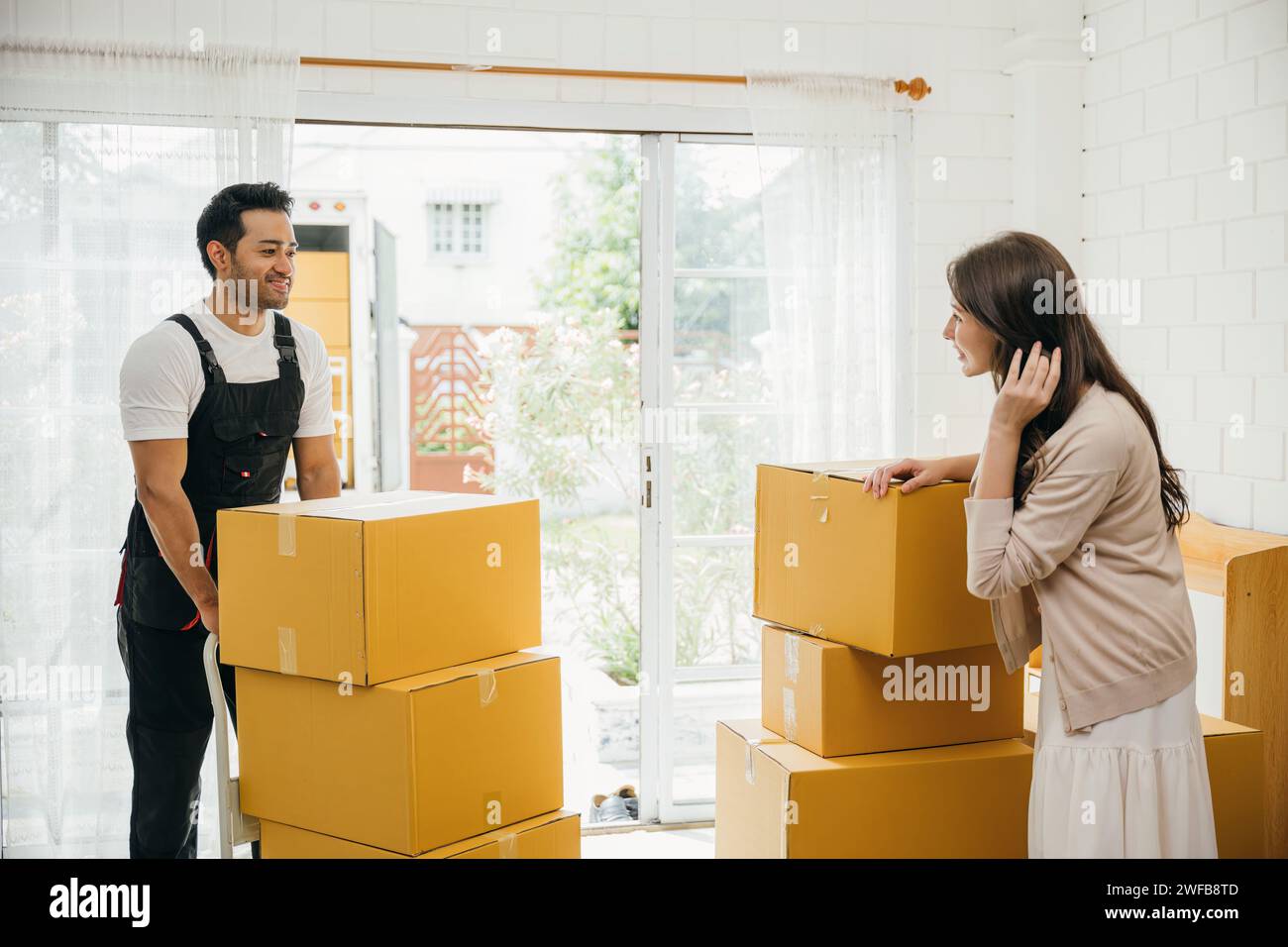 Inside their home a couple receives adept moving assistance. Uniformed ...