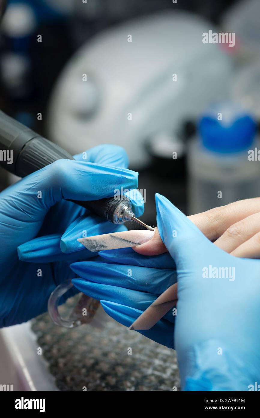 Detailed view of the EDGE nail shaping process, capturing the precise ...