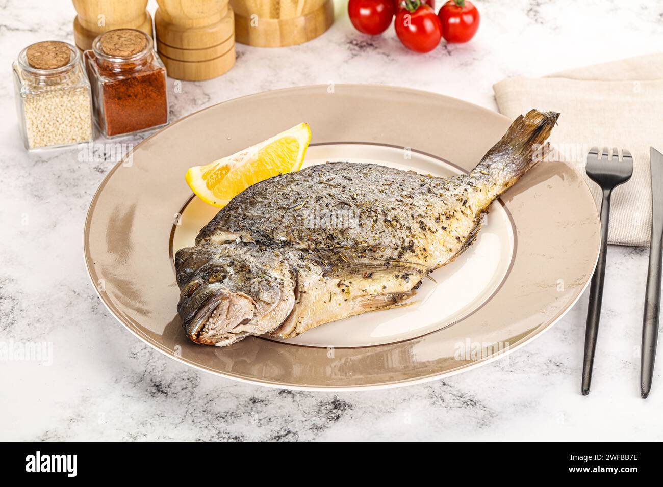 Baked Dorado fish served lemon slice Stock Photo - Alamy