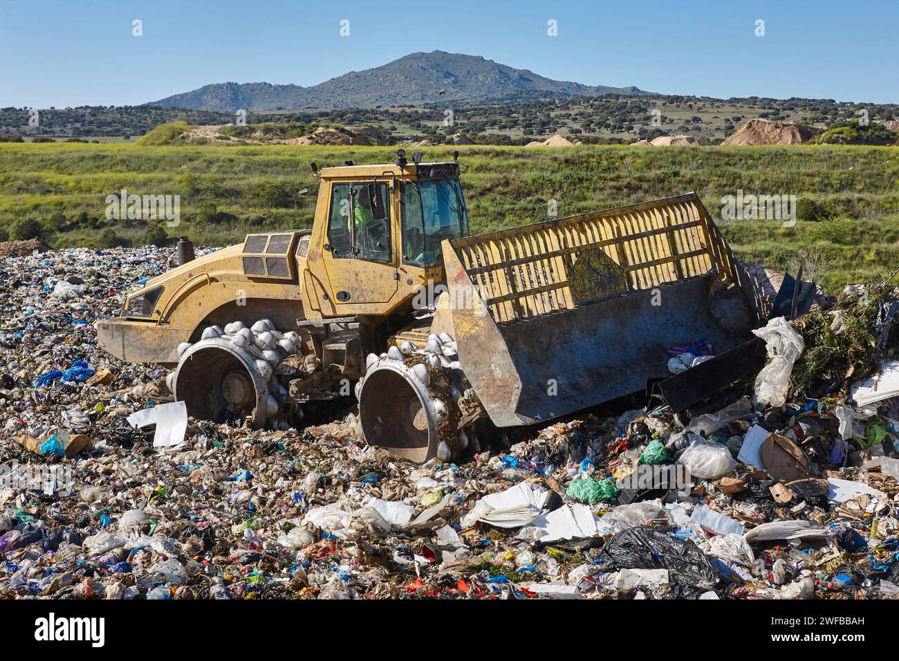 Heavy machinery shredding garbage in an open air landfill. Waste Stock ...