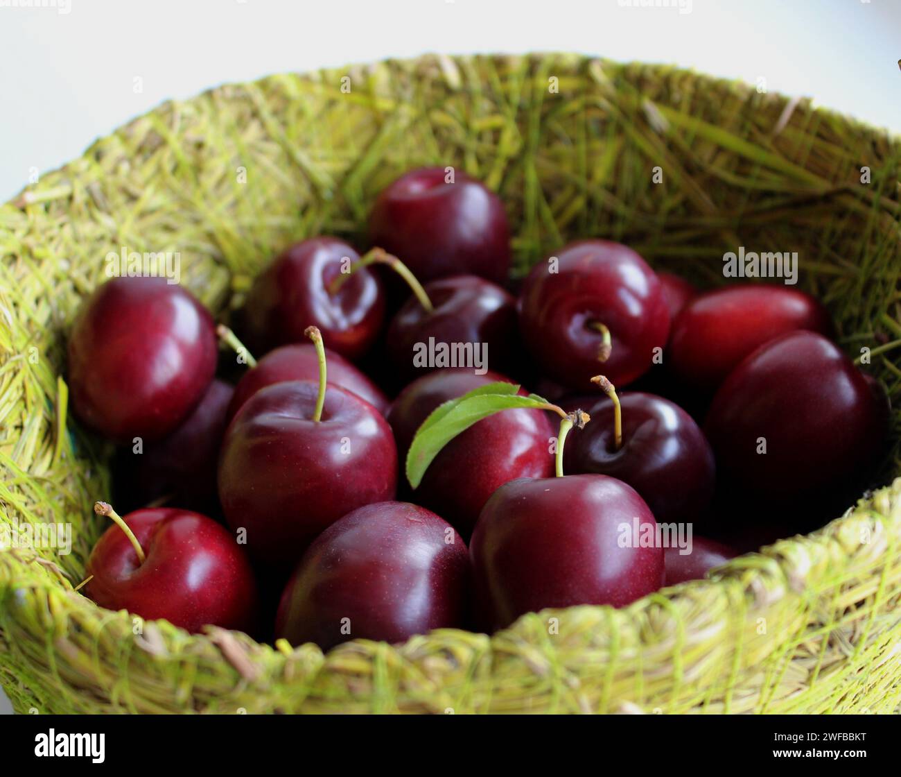 Seasonal Harvesting. Freshly Picked Red Plum Fruits Inside Grass Woven ...