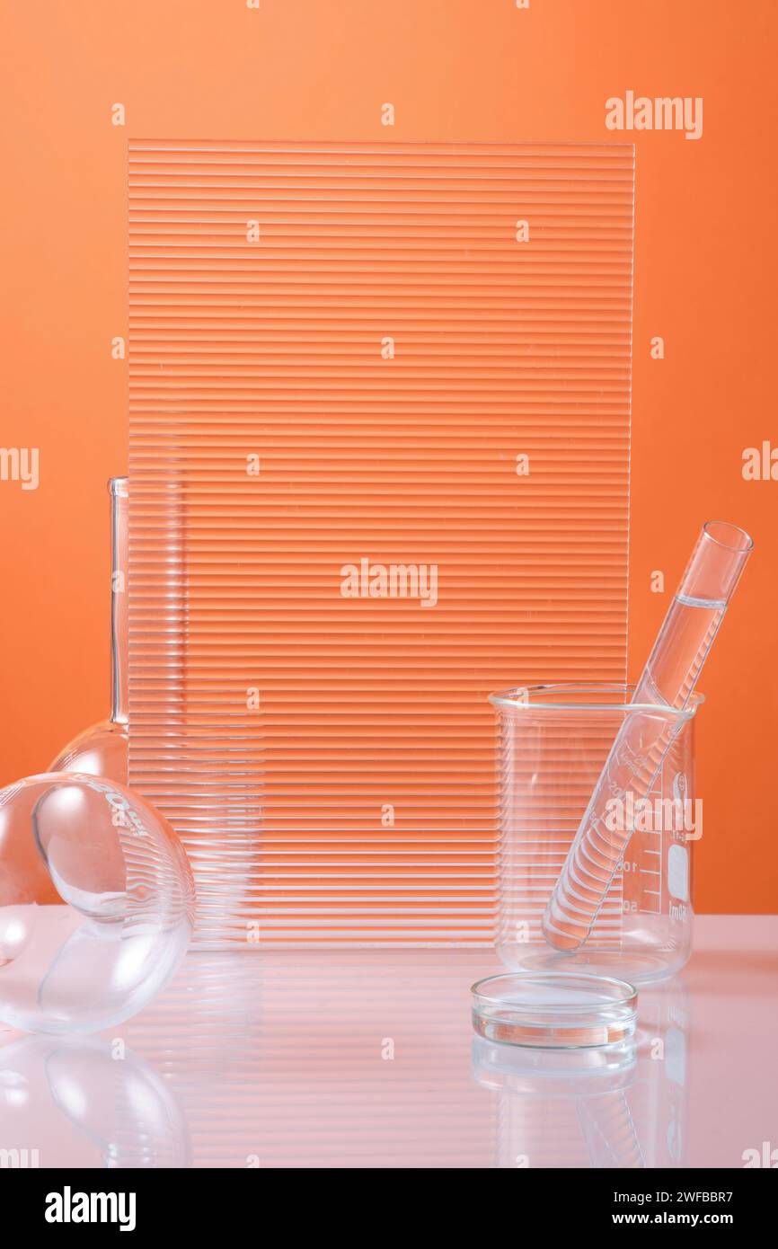 A glass petri dish, a beaker with a test tube of liquid inside and a ...