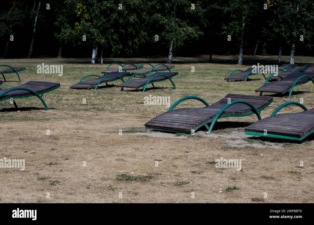 empty wooden sun beds on an empty grassy beach Stock Photo - Alamy