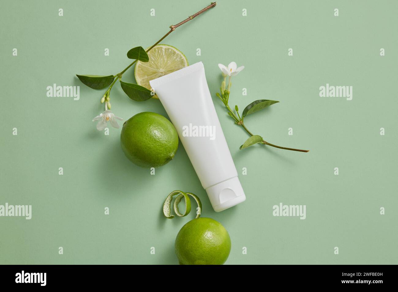 Top view of a white tube with empty label decorated with some Limes and ...