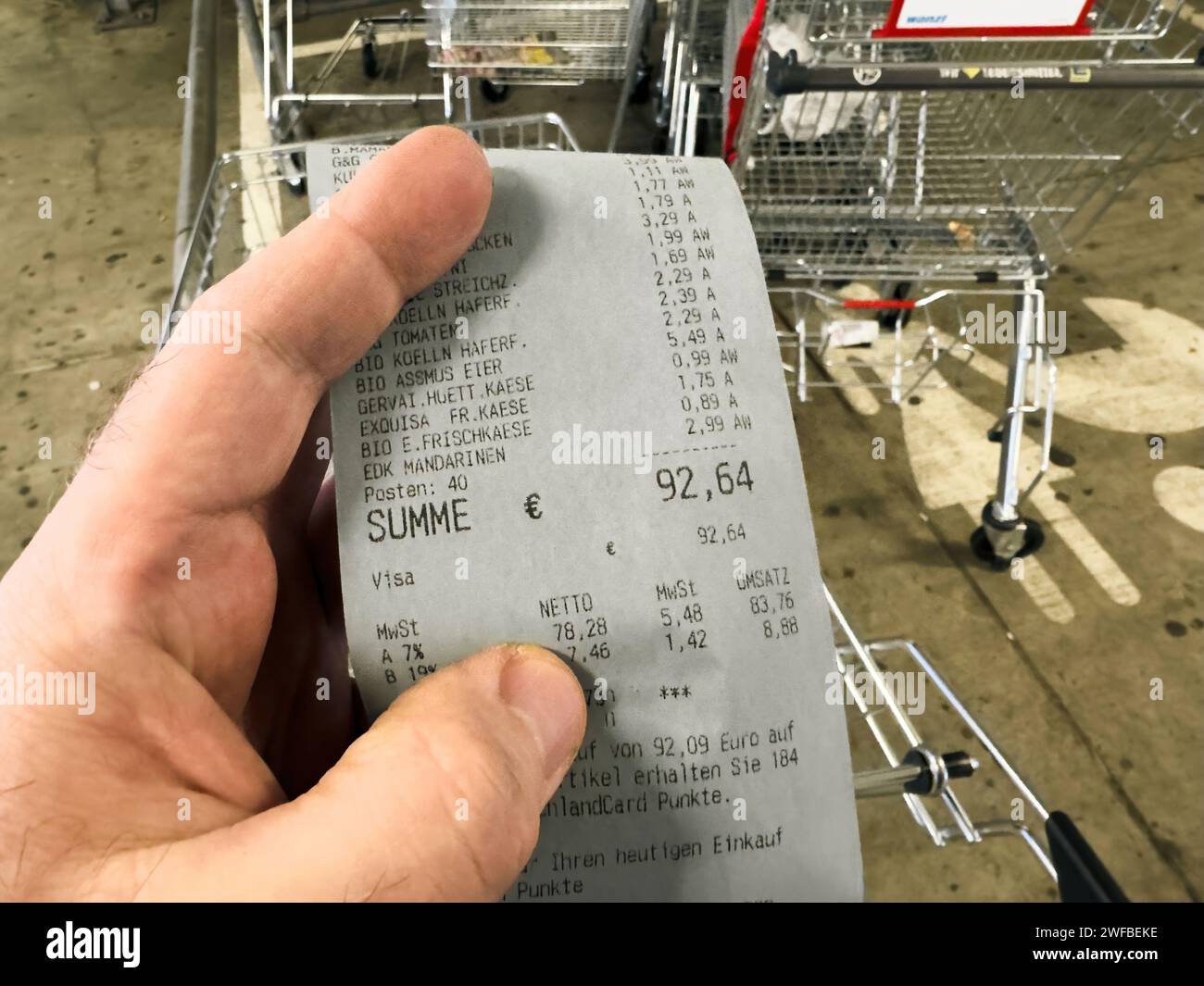 Berlin, Germany - Jan 23, 2024: A male hand holding a price slip ...