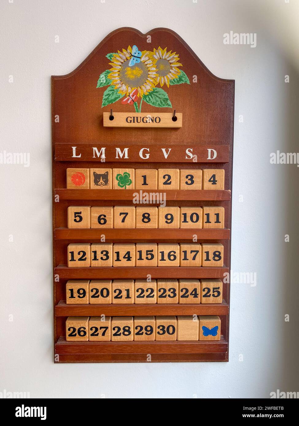 a wood italian calendar showing June month days with moving pieces hang ...