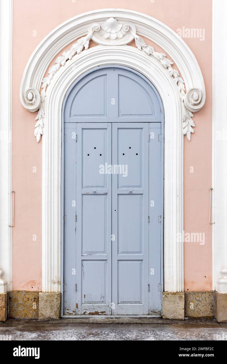 Arched closed gray wooden door in pink wall, background texture ...