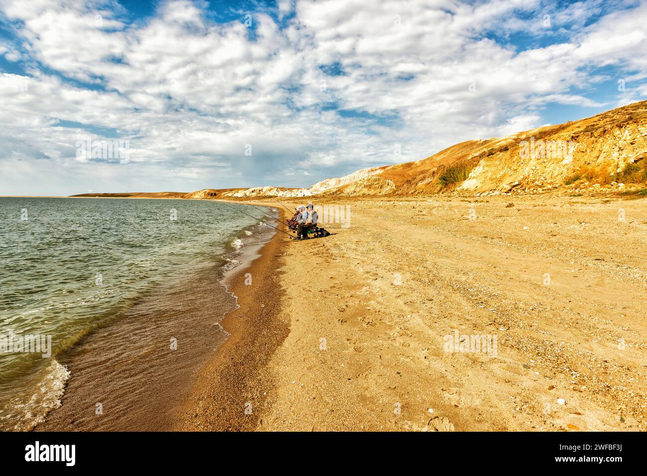 Landscape of a deserted lake shore with fishermen Stock Photo - Alamy