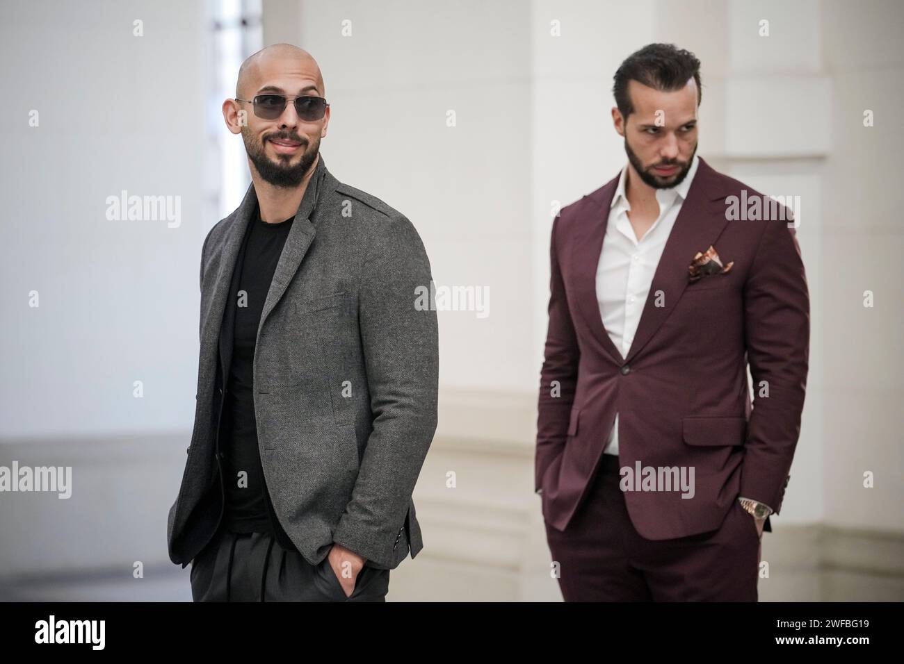 Andrew Tate, left, and his brother Tristan, right, wait inside the ...