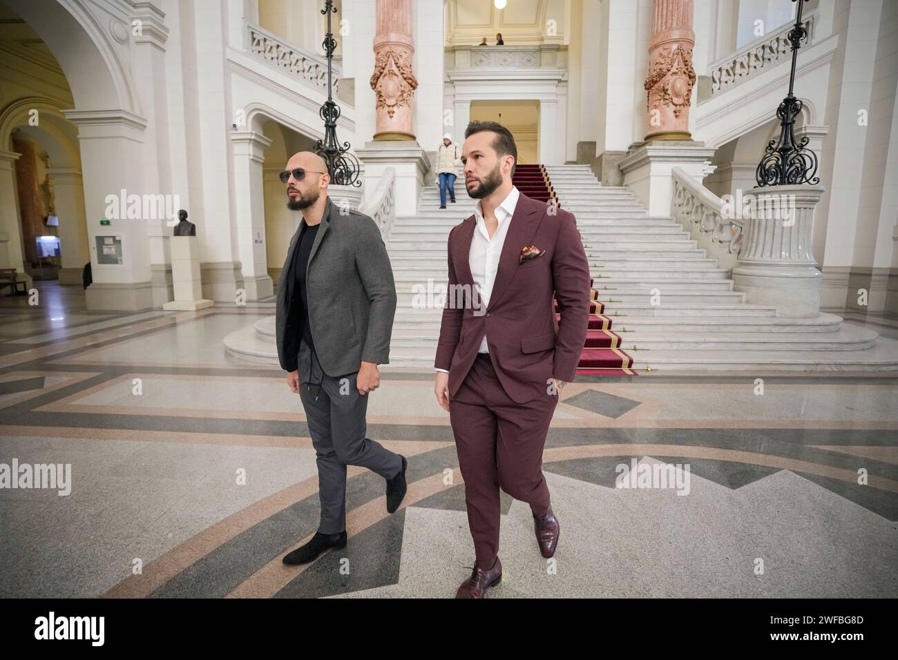Andrew Tate, left, and his brother Tristan walk inside the Court of ...