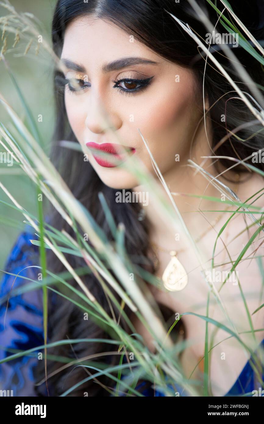 Beautiful woman looking through plants Stock Photo - Alamy