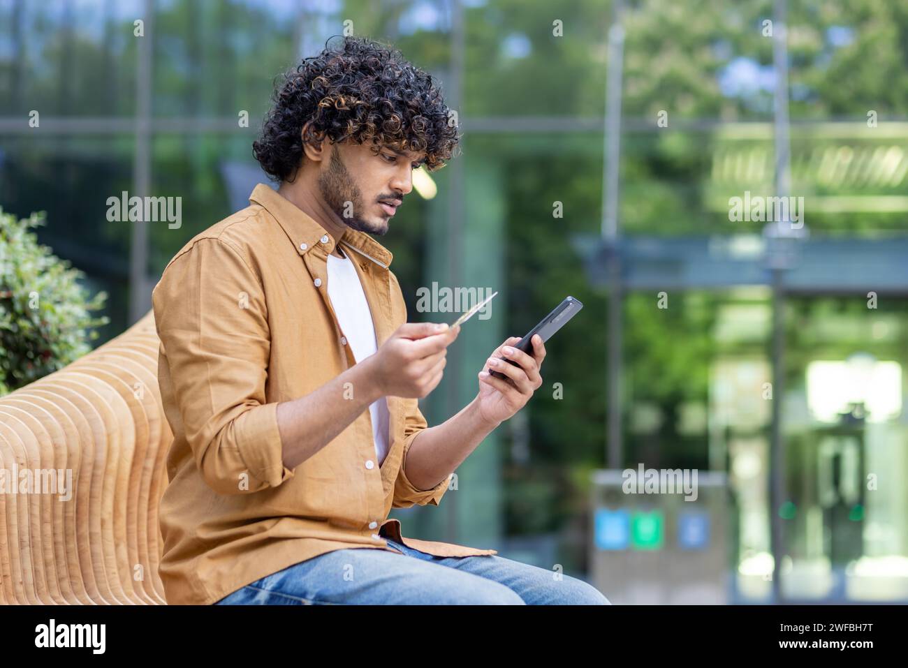 Upset and disappointed young Indian man looking at phone screen and ...