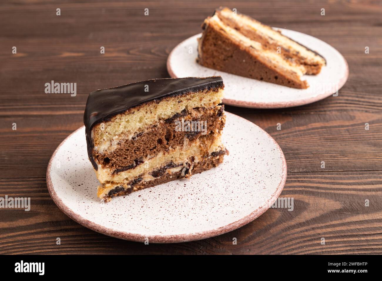 Chocolate biscuit cake with caramel cream on brown wooden background ...