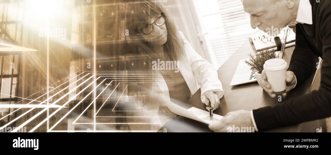 Two mature business people working together in office; multiple ...