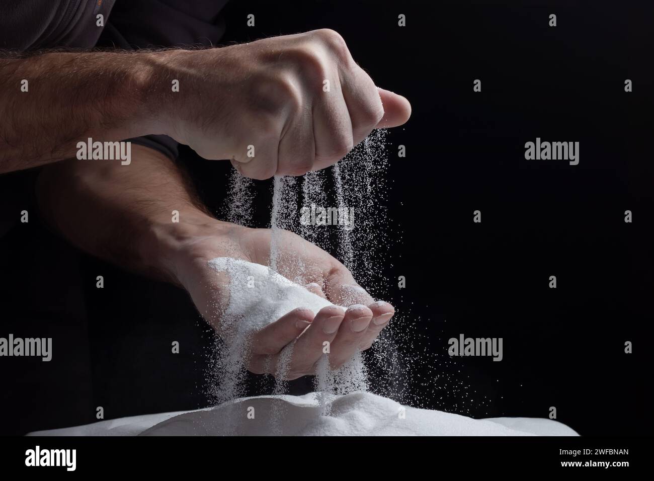 Men's hands keep sand in their palms and spilling grains of sand ...