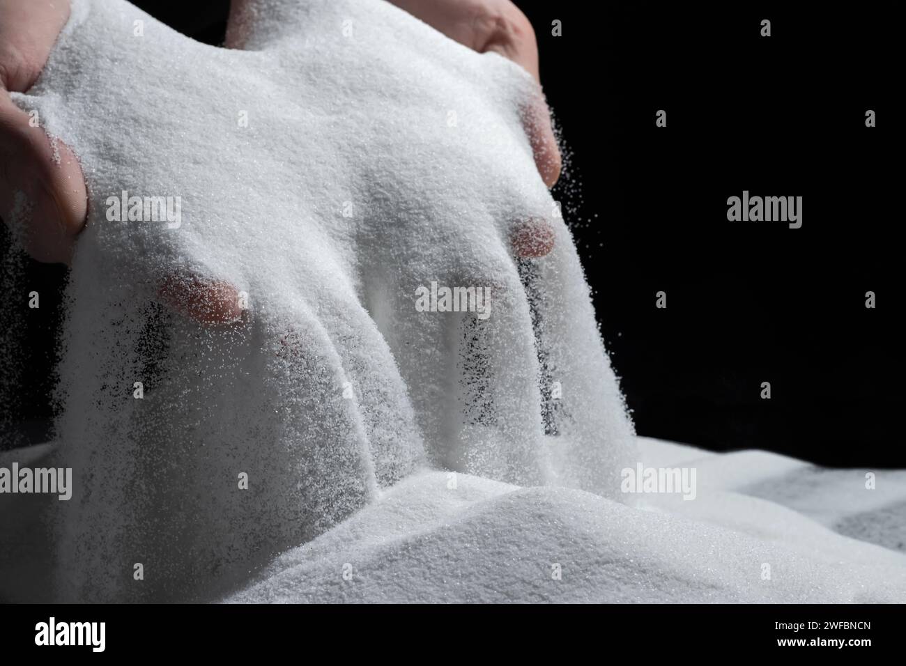 Men's hands keep sand in their palms and spilling grains of sand ...