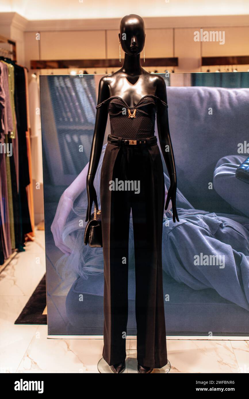 Stylish mannequin in a boutique window dressed in a black pants with ...