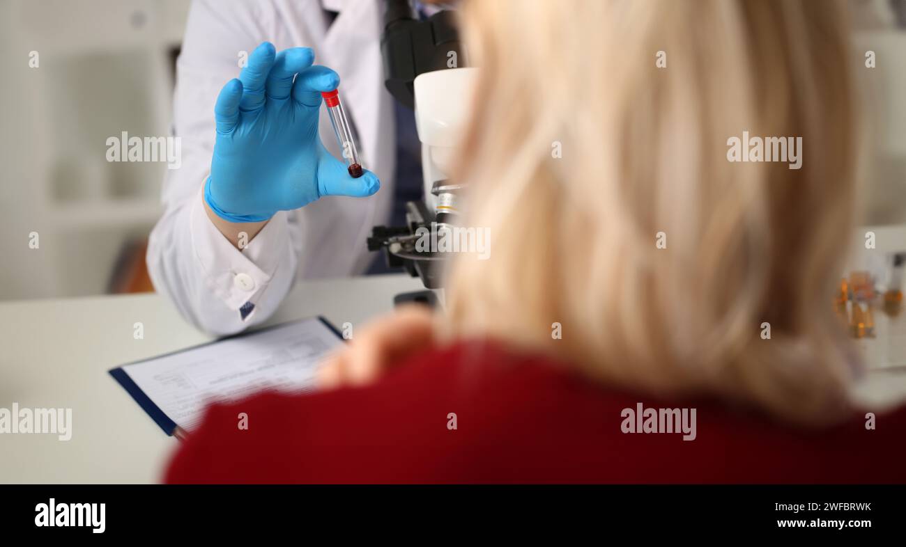 Doctor holds analyzed blood sample front patient Stock Photo - Alamy
