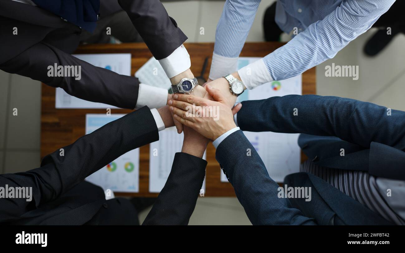 Group men in suits hold out their hands in unity Stock Photo - Alamy