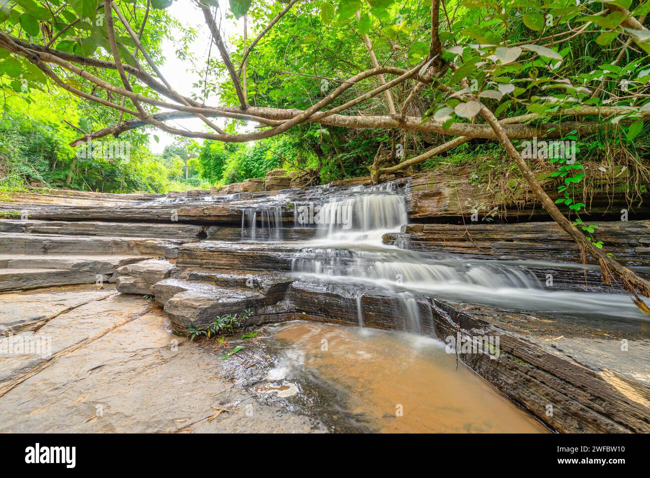 Waterfall called Tat Yai Waterfall with rock layer and green forest ...