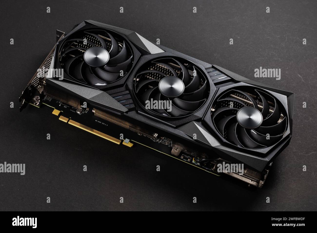 video card with three coolers from the computer on a dark background ...
