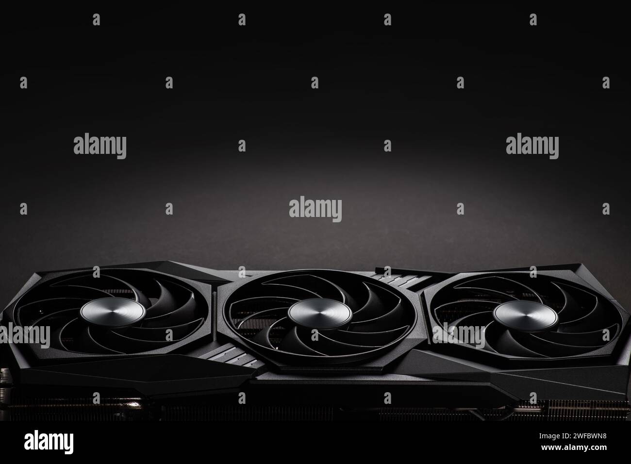 video card with three coolers from the computer on a dark background ...