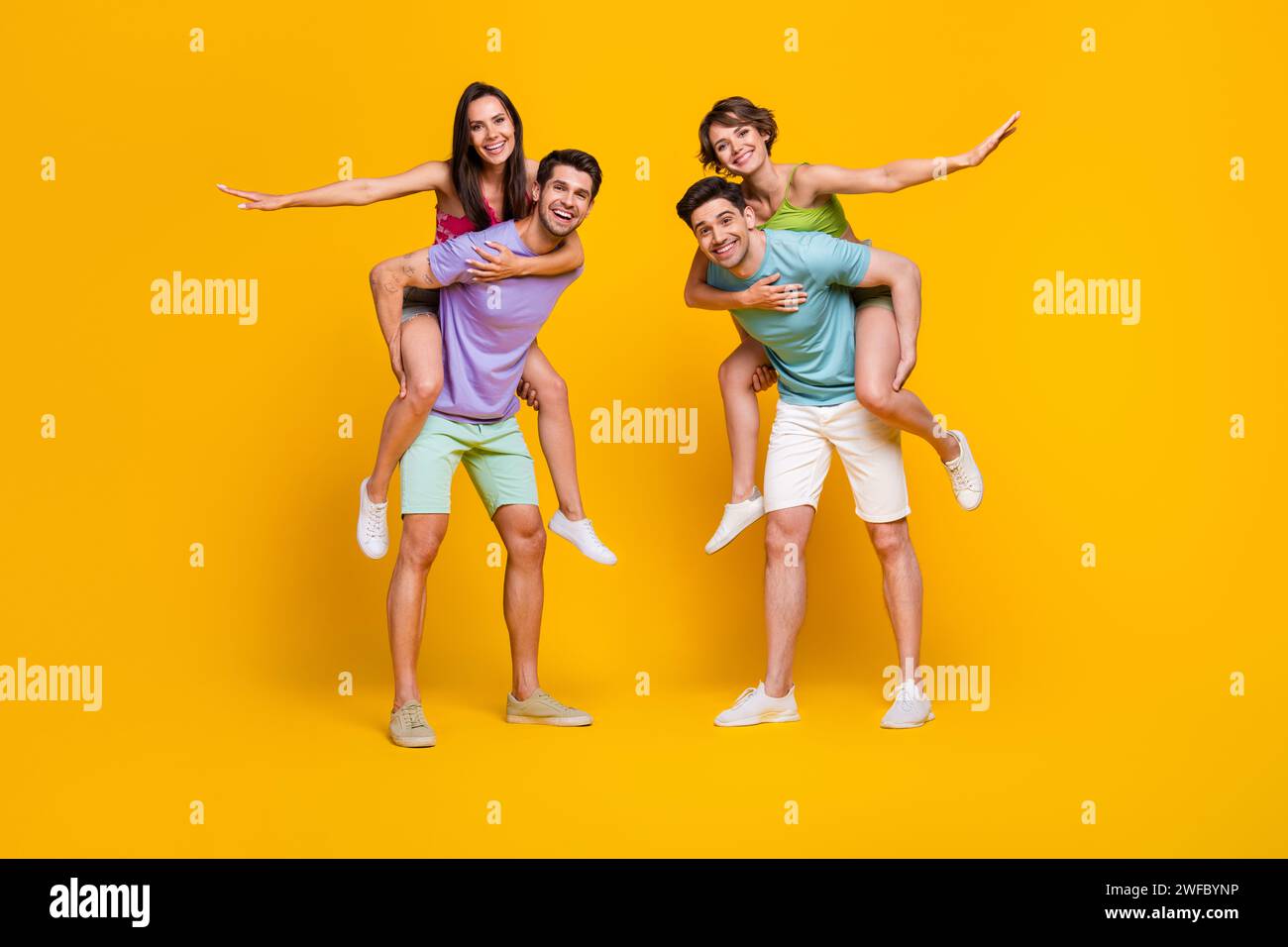 Full length photo of fellows have fun playing plane guy piggyback girls ...