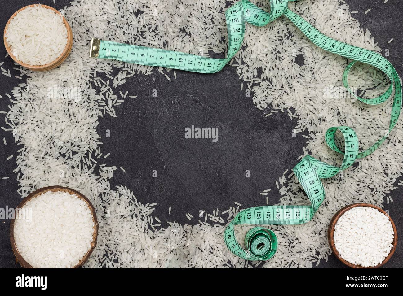 Basmati rice is scattered on table. Round rice in wooden bowl. Rice in ...