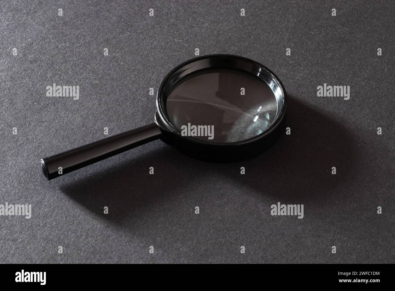 magnifying glass on black texture background with shadow Stock Photo ...