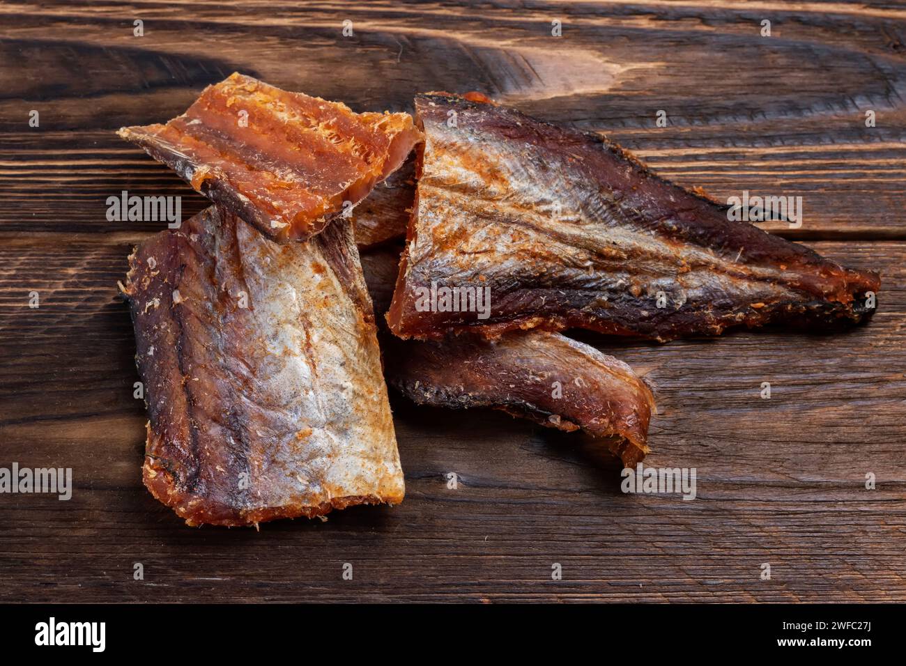 Pieces of cleaned dried fish on wooden background. Dry Peppered Pollack ...
