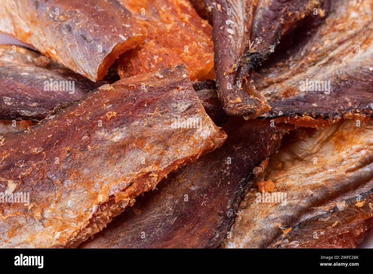 Pieces of cleaned dried fishbackground. Dry Peppered Pollack. Amber ...