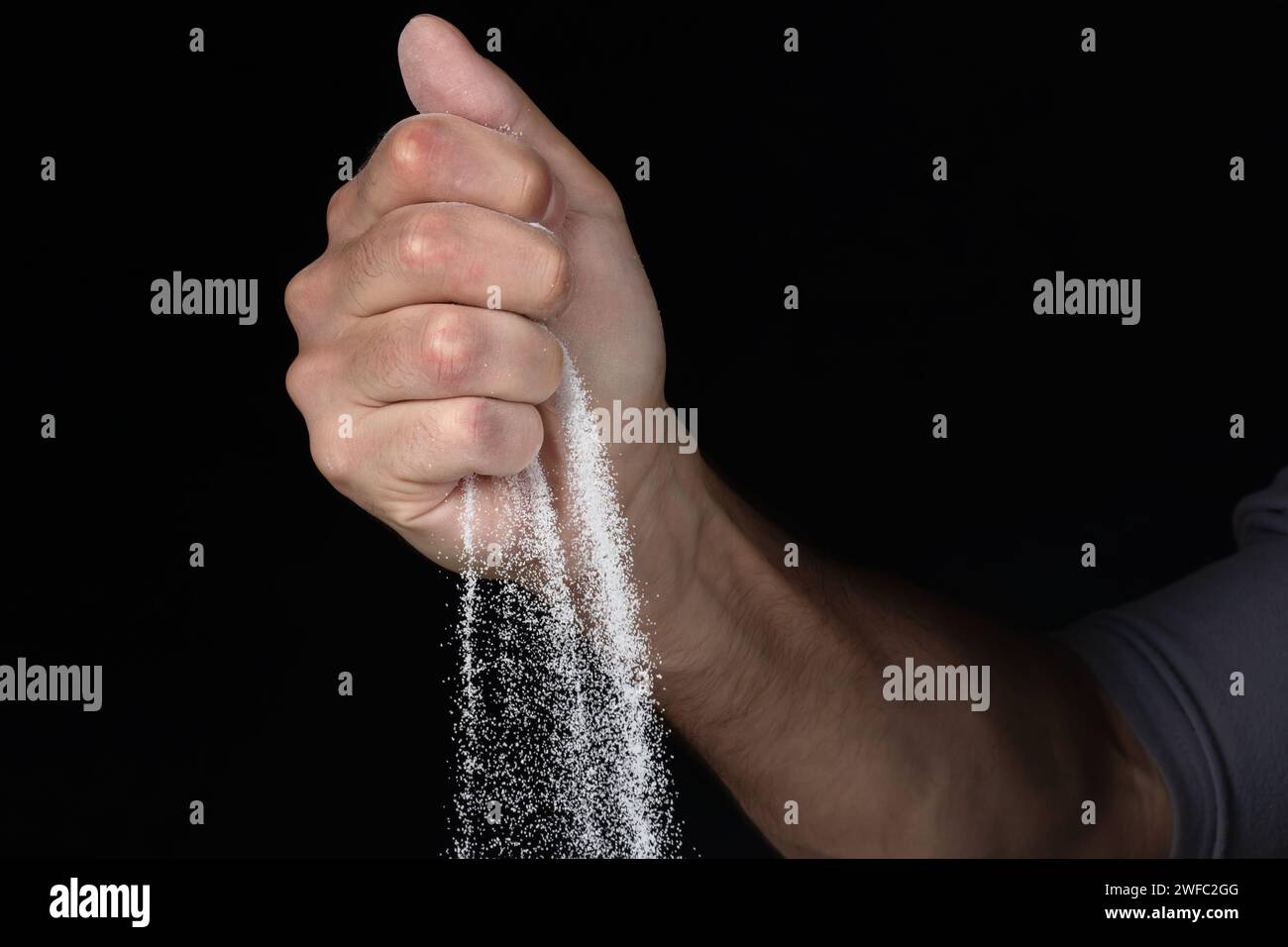 White sugar falling in black hi-res stock photography and images - Alamy