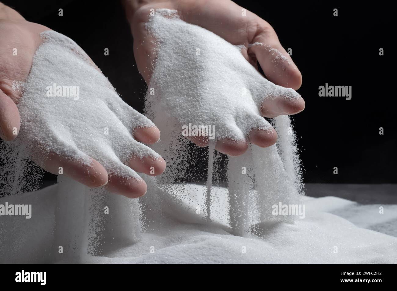 Men's hands keep sand in their palms and spilling grains of sand ...