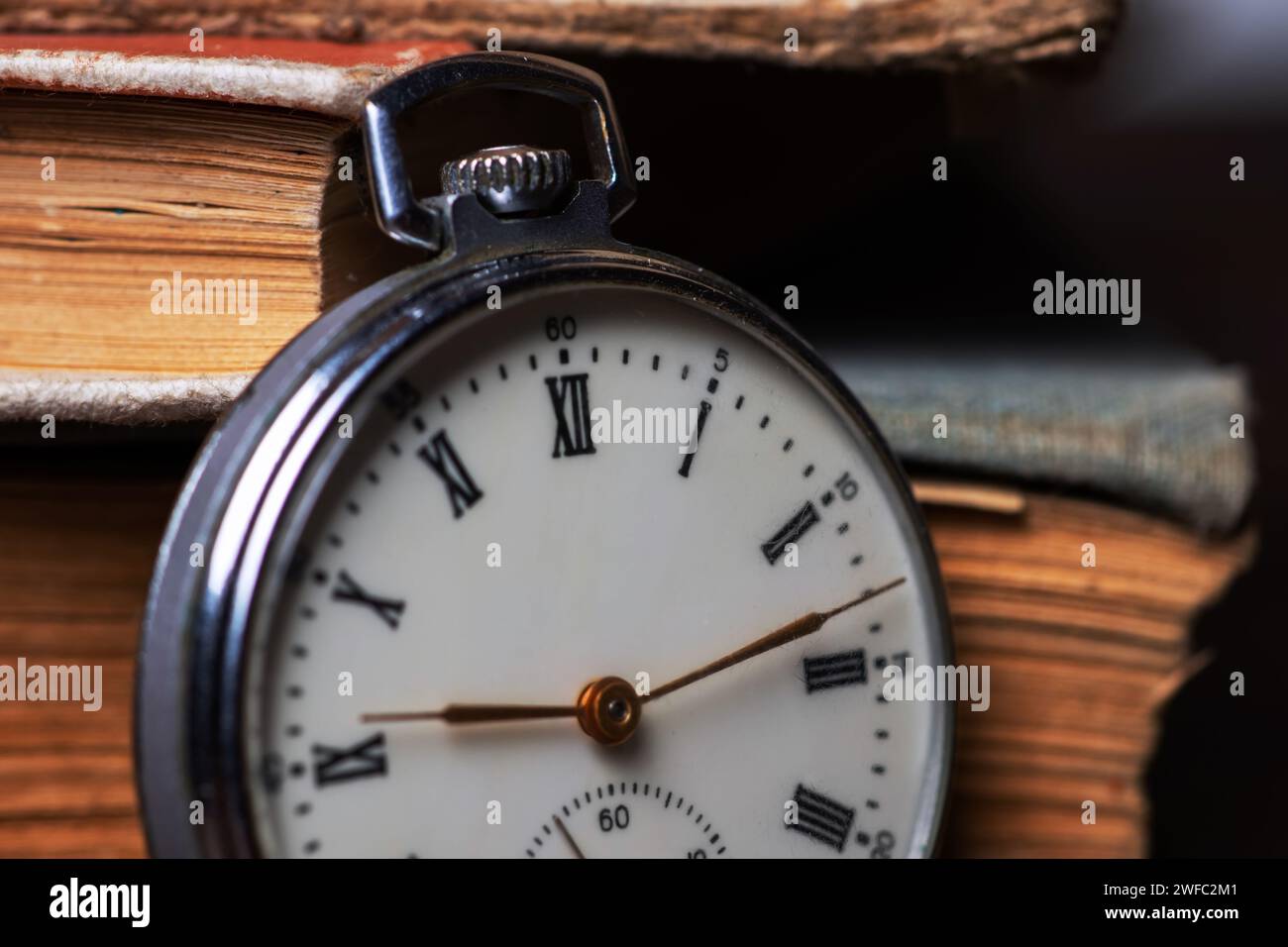 Vintage pocket watch on the background of old books Stock Photo - Alamy