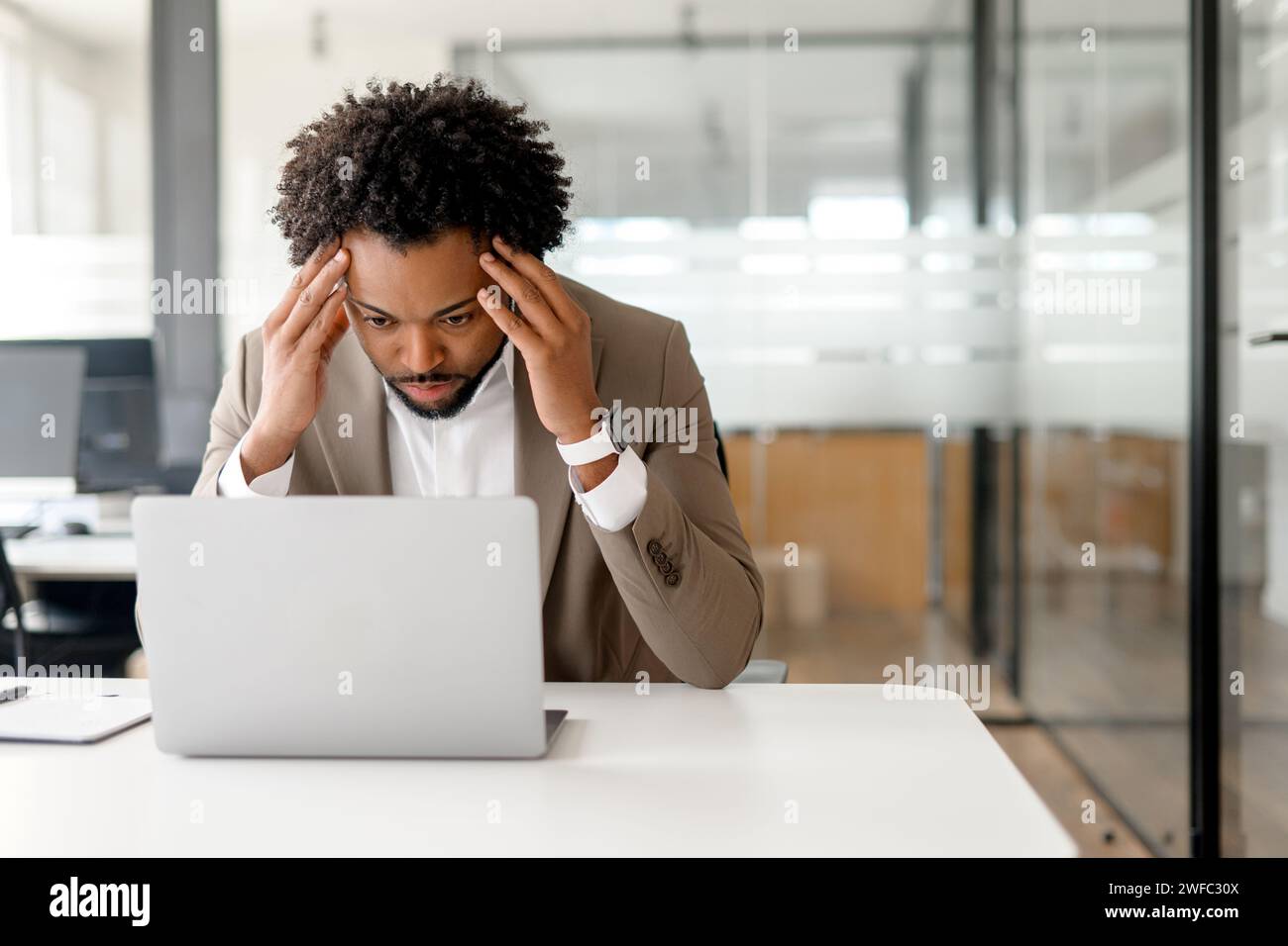 Stressed African-American businessman shows signs of concern as he ...