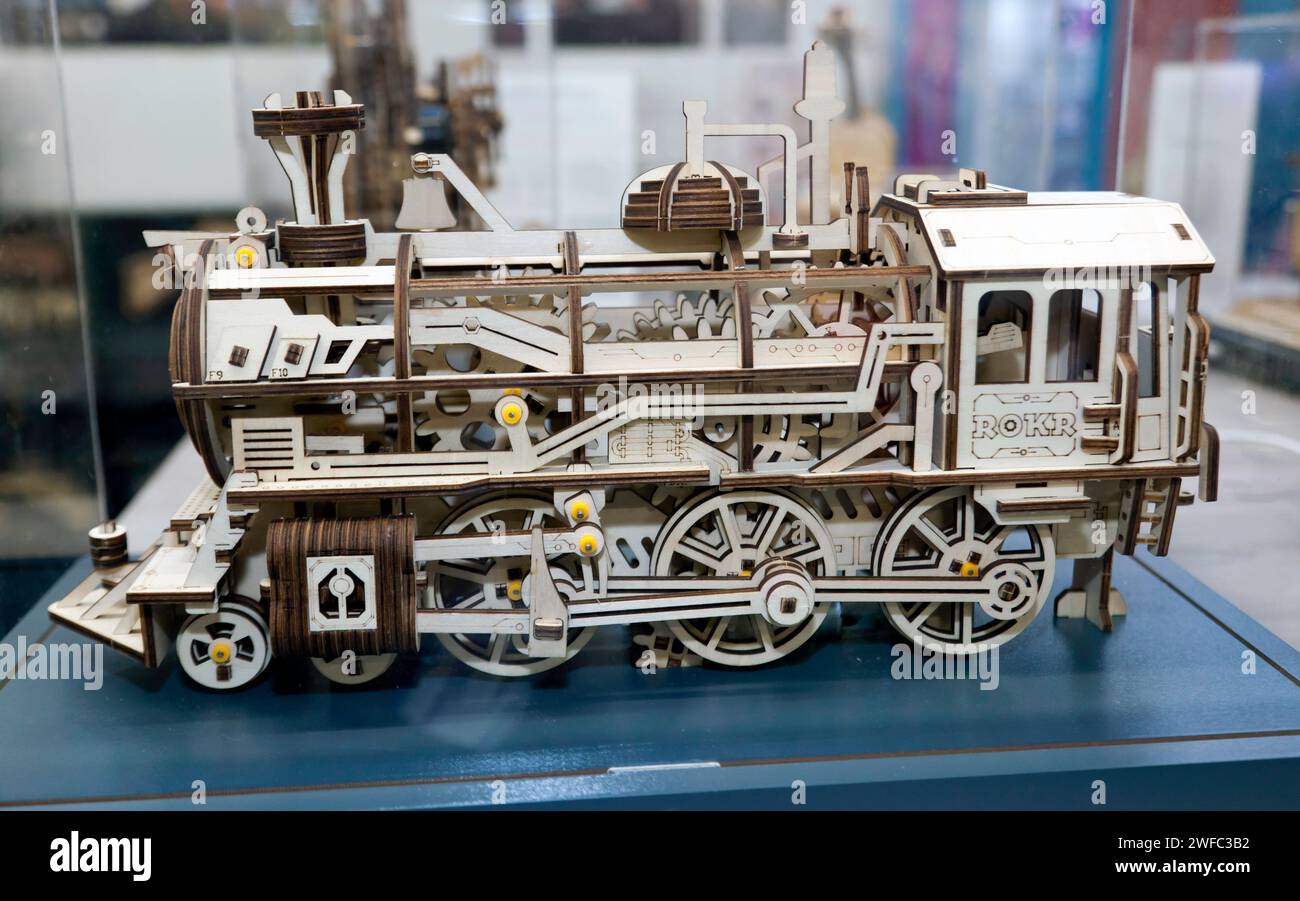 Close-up of a ROKR Locomotive Mechanical Gears 3D Wooden Puzzle, on the Robotime stand, at the ...