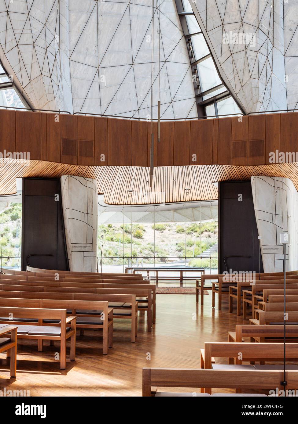 Temple interior with timber benches and view of translucent wings. Bahá ...
