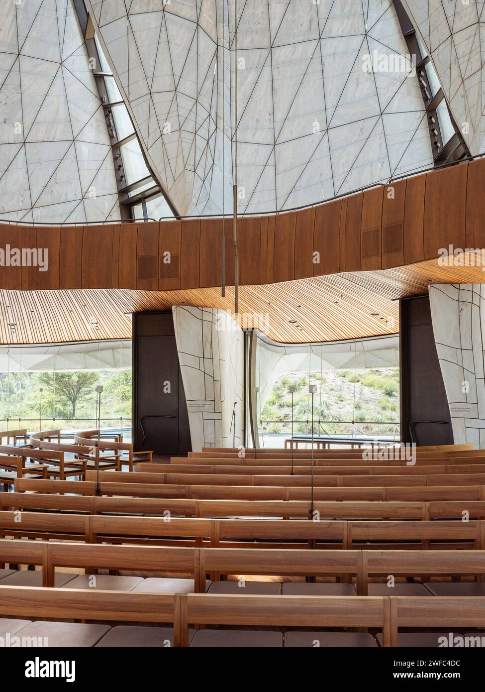 Temple interior with timber benches, balcony and view of translucent ...
