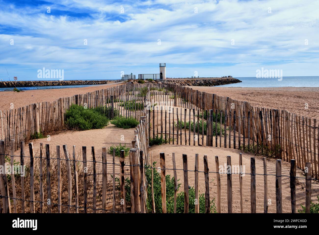 Walkway leading to a beach enclosed by a sandy area and fencing Stock ...
