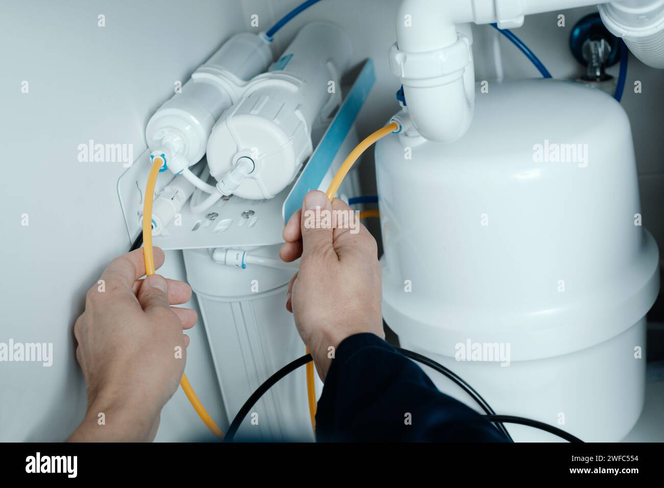 closeup of a caucasian man, wearing blue overalls, installing a reverse ...