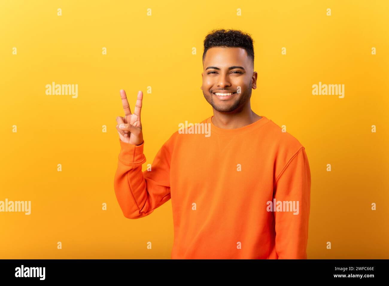 Happy satisfied man showing v sign symbol of peace with fingers ...